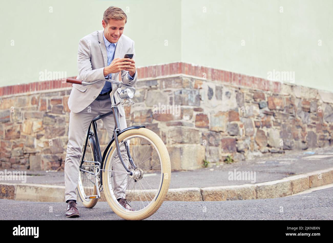 Dont ride and text. a young businessman using his smartphone while ...