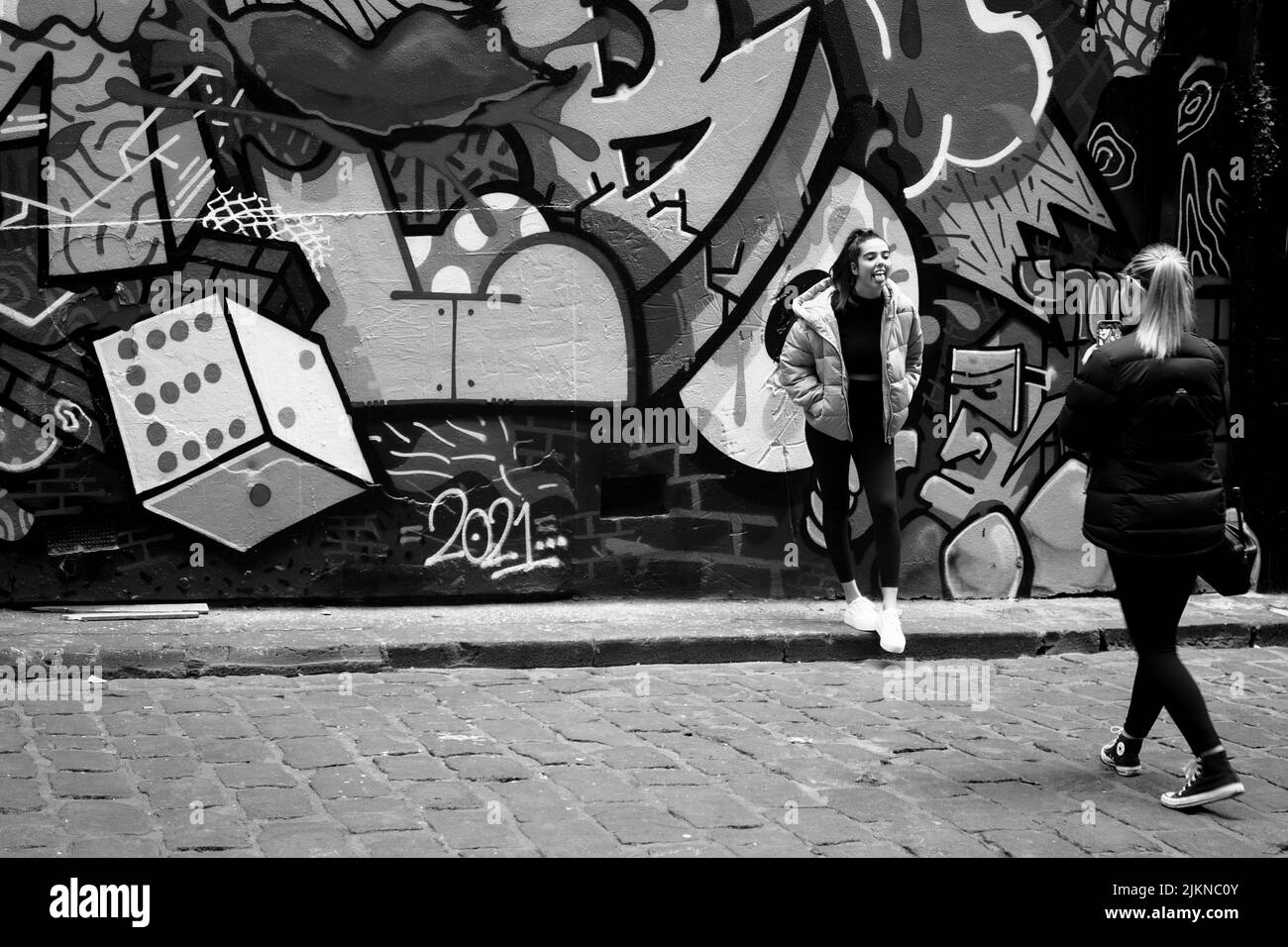 A grayscale shot of the girls taking photos against the wall with ...