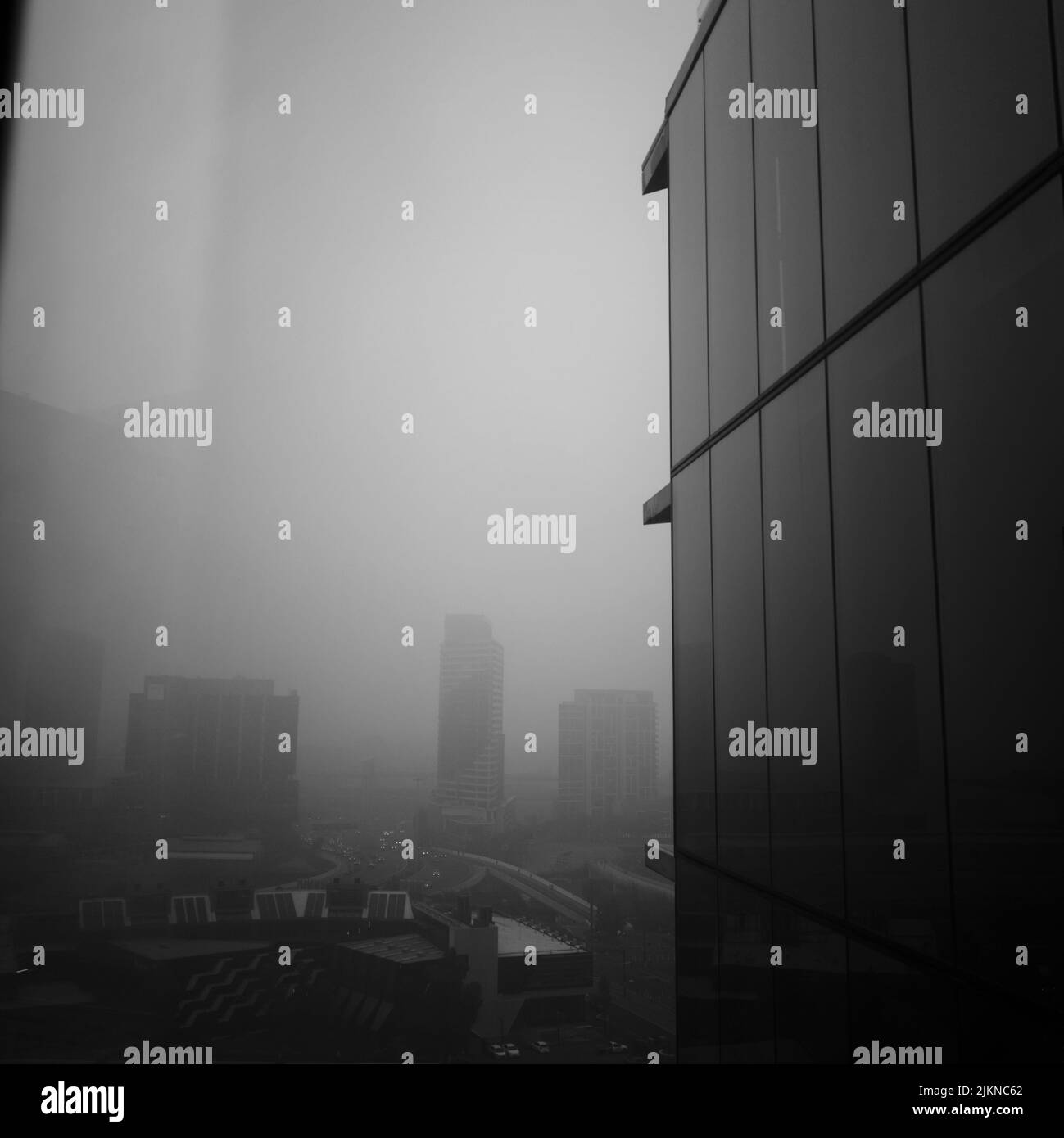 A grayscale of a modern tall building wall on a foggy day Stock Photo ...