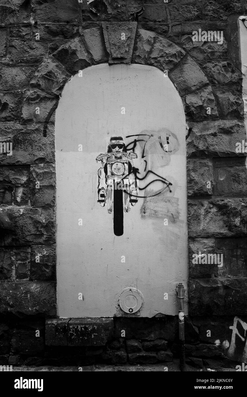A vertical grayscale shot of street art with a biker in Melbourne's ...