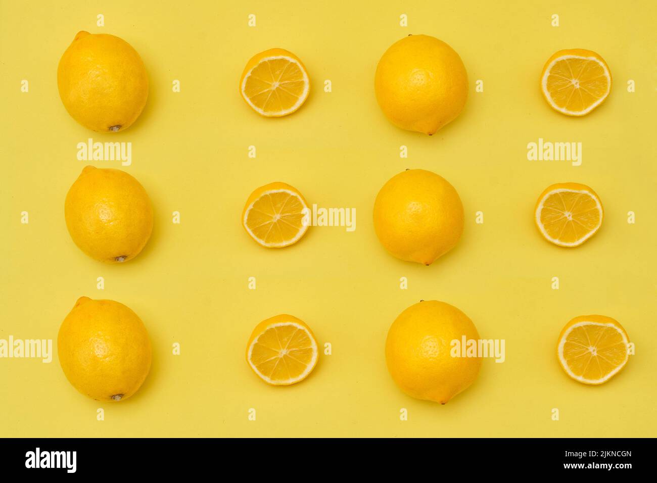 Lemon top view with halves and whole ripe lemons on yellow background ...