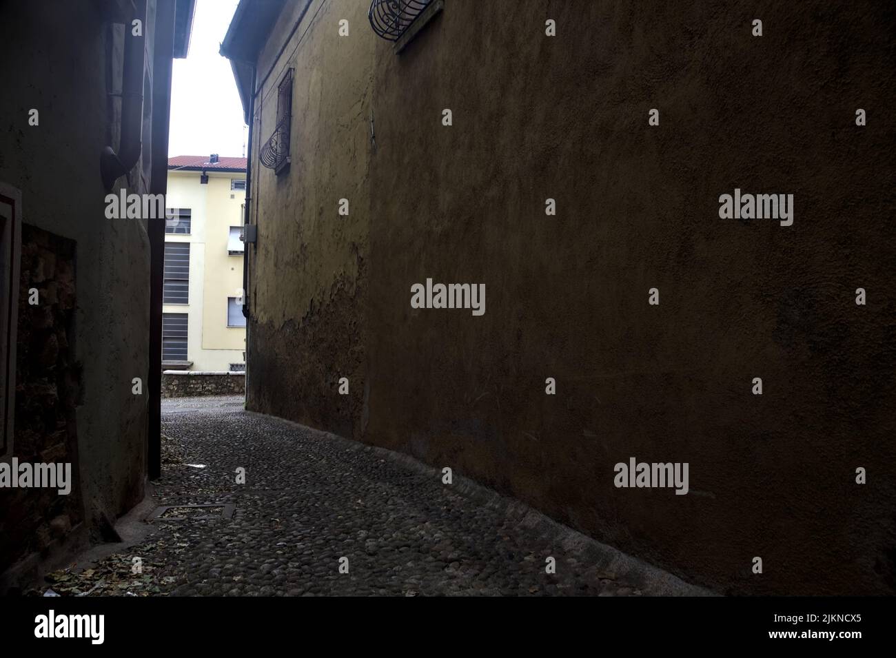 Very narrow cobbled alley in an italian town Stock Photo - Alamy