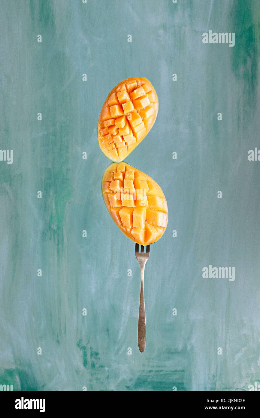A vertical shot of mango with a fork on blurred background Stock Photo ...