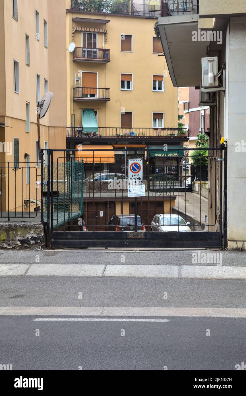 Shops opposite to a road seen through gates Stock Photo - Alamy