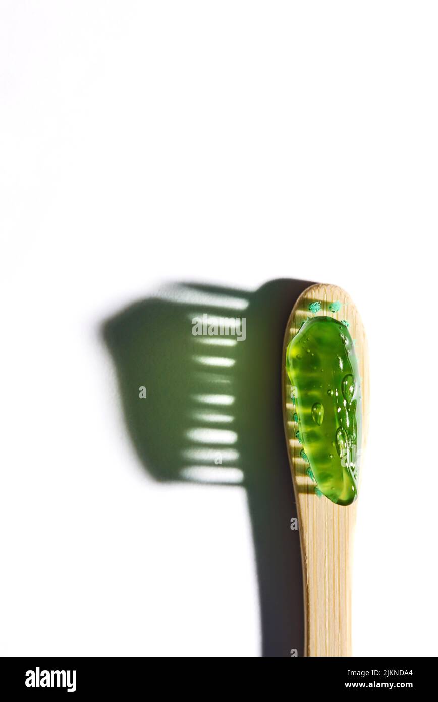 A closeup photo of a bamboo toothbrush with mint green bristle and ...