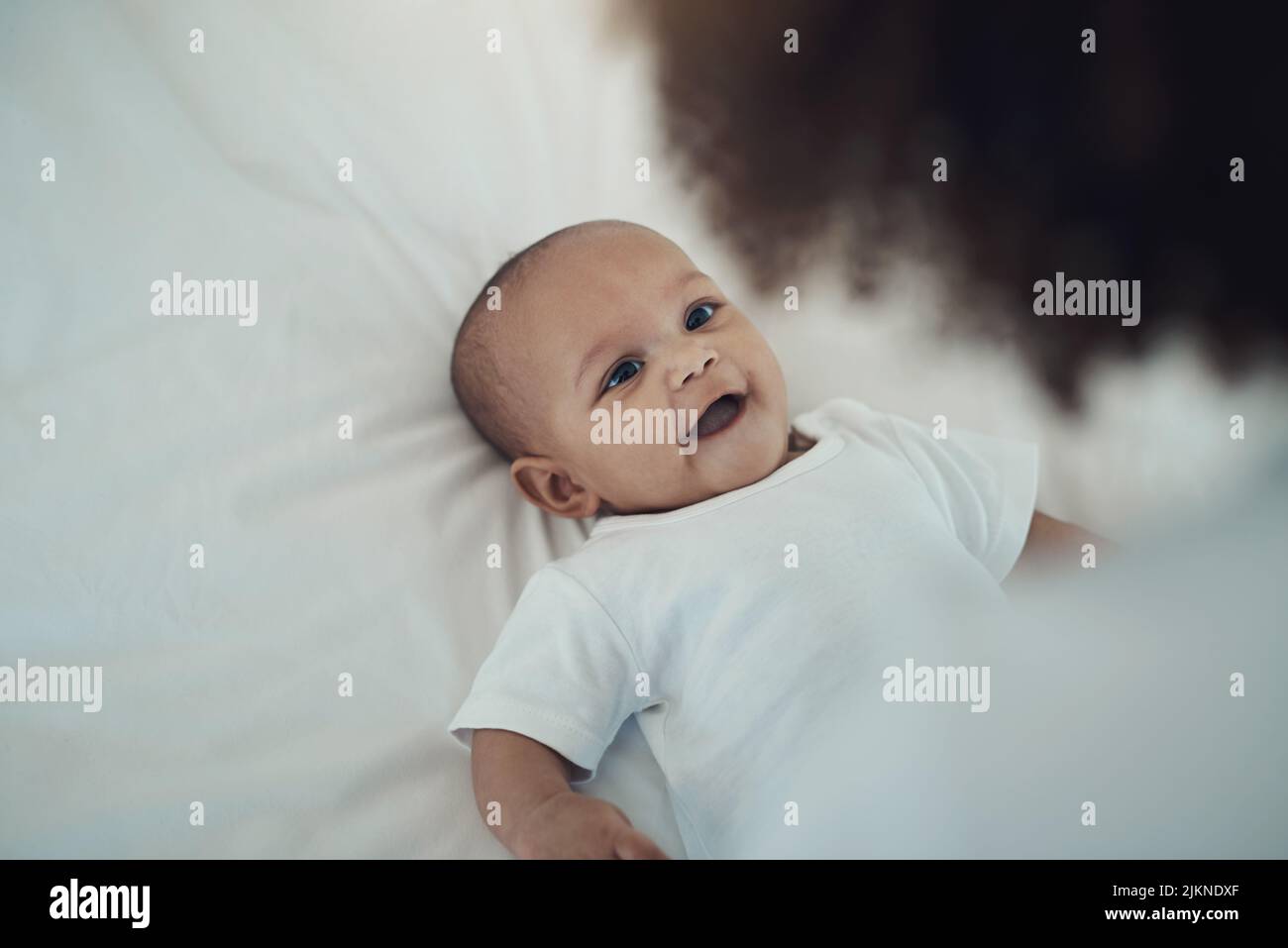 One baby, so many smiles. an adorable baby girl gazing at her mother on ...