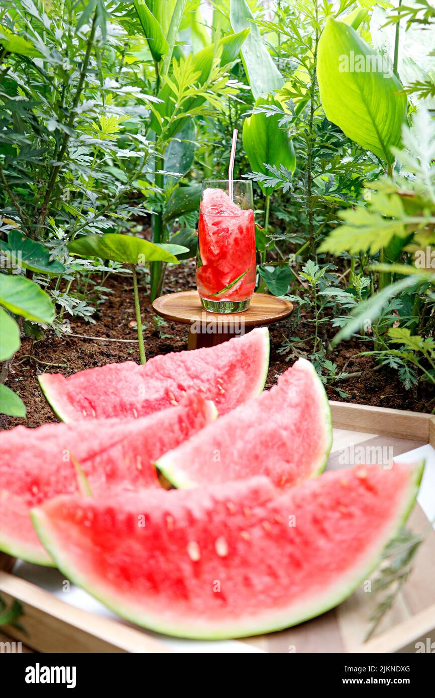 A closeup shot of sliced watermelon and a glass of refreshing ...