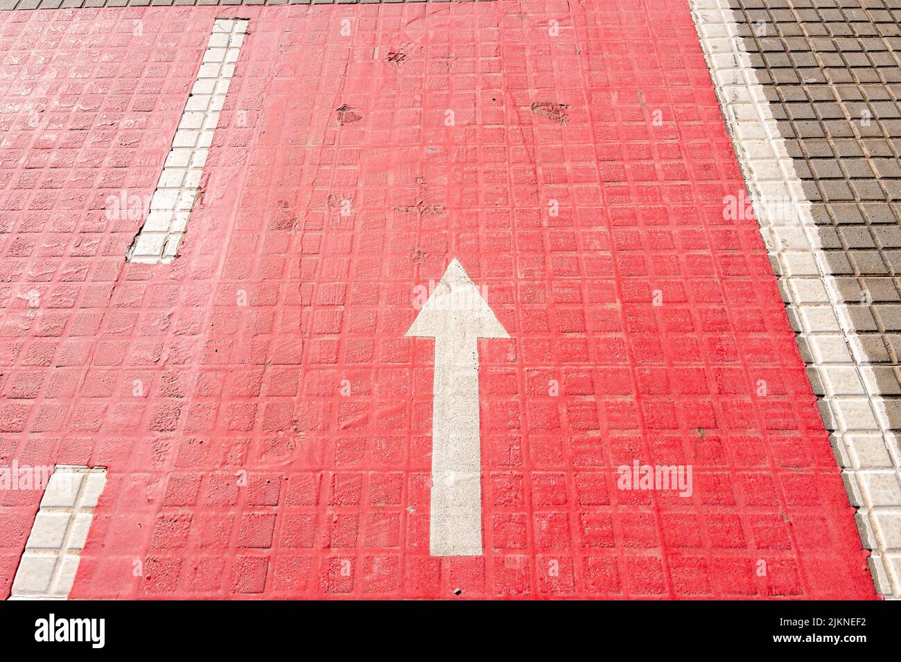 A photo of an arrow sign on red cycle path Stock Photo - Alamy