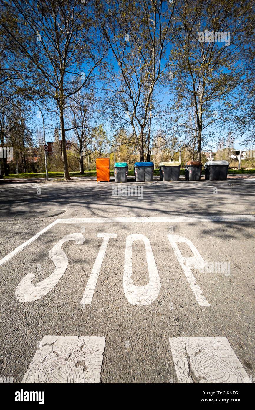 A vertical shot of a road with stop road marking and trees in a city ...