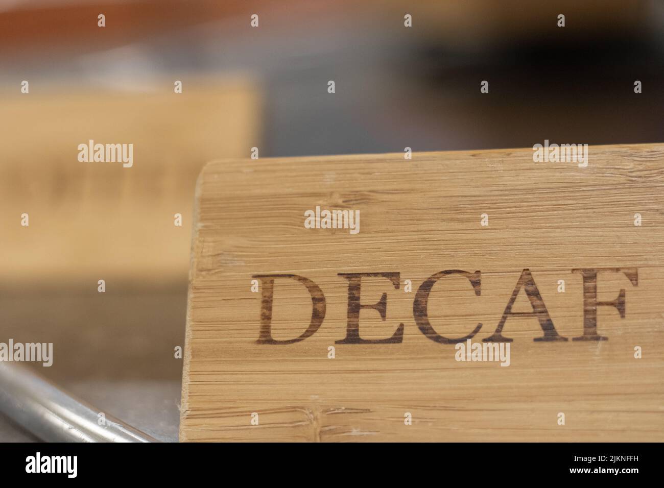 A small wooden decaf coffee sign on a metal counter Stock Photo - Alamy