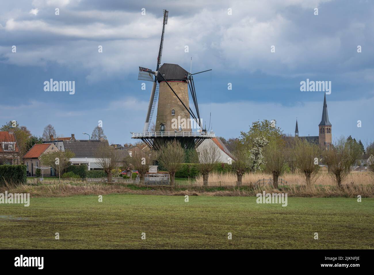 Dutch countryside with traditional windmill next to the church in ...