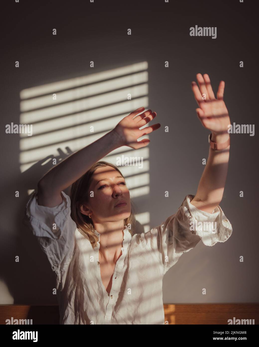 A beautiful Caucasian woman blocking sunlight passing the window Stock ...