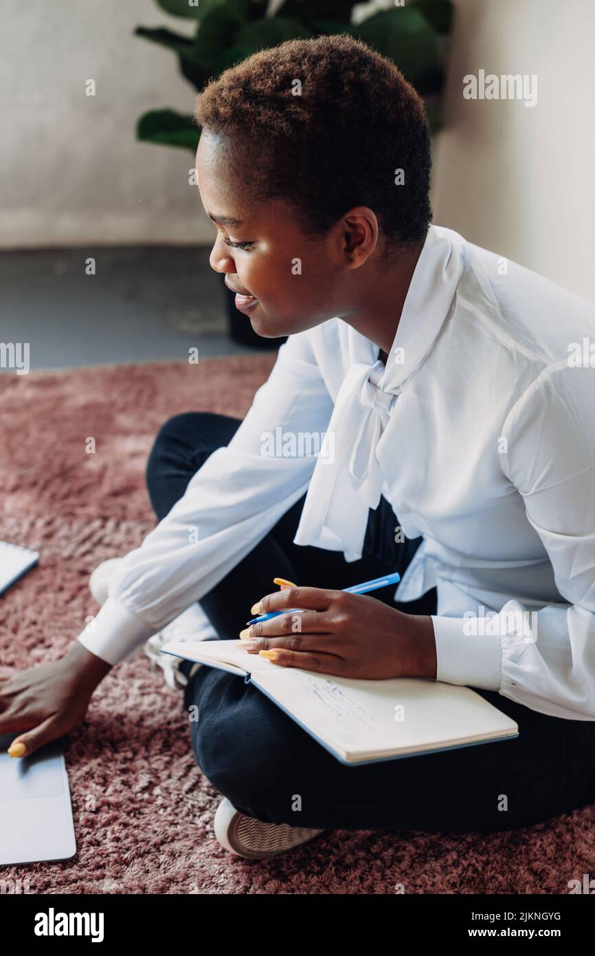 Girl sitting on the floor writing book hi-res stock photography and ...