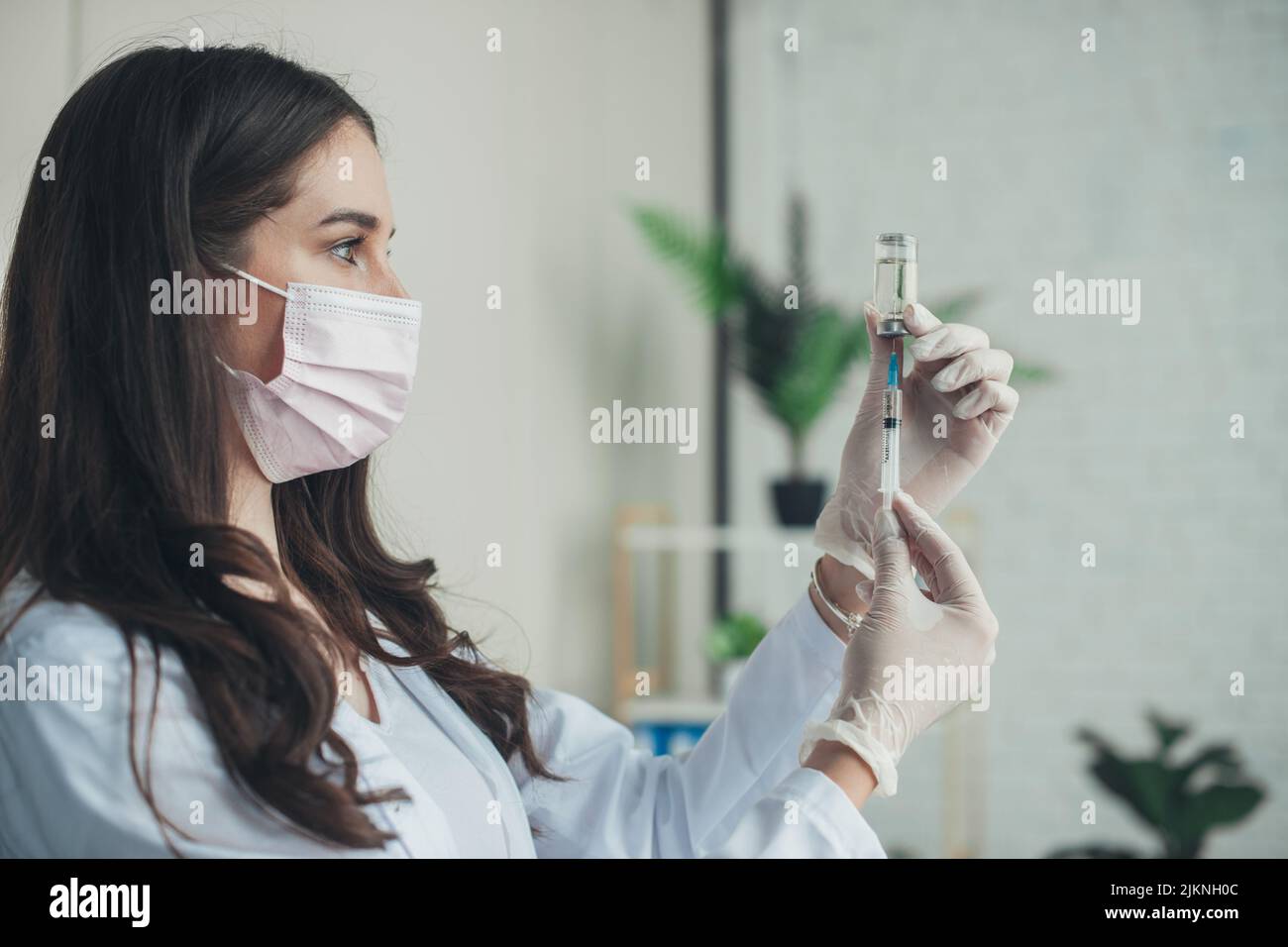 Female doctor preparing a dose of vaccine for a patient, in the ...