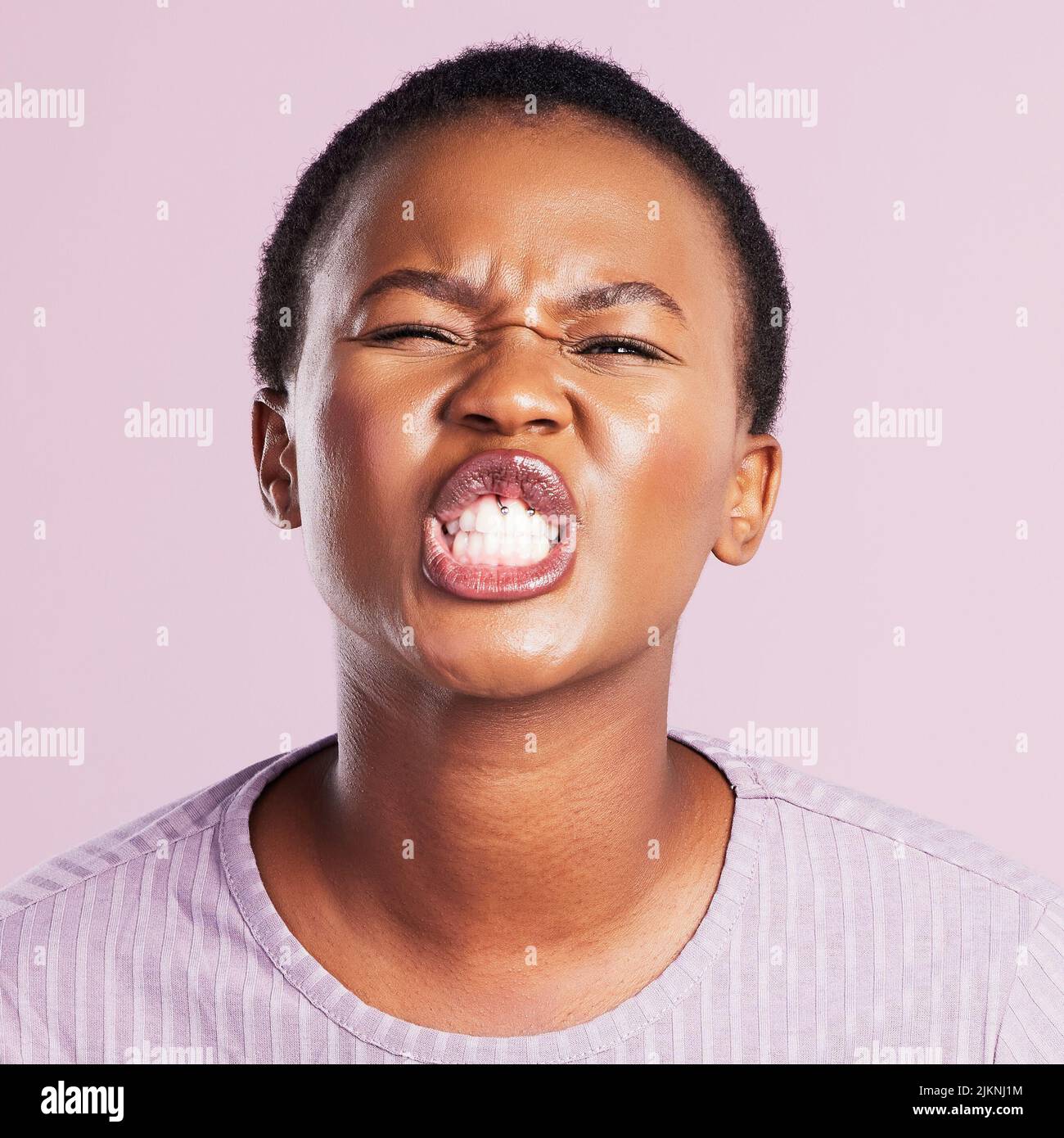 Just having some fun. Studio shot of a young woman making a silly face ...