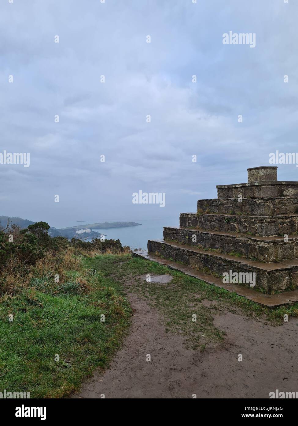 A vertical shot of an archeological sire with the sea in the background ...