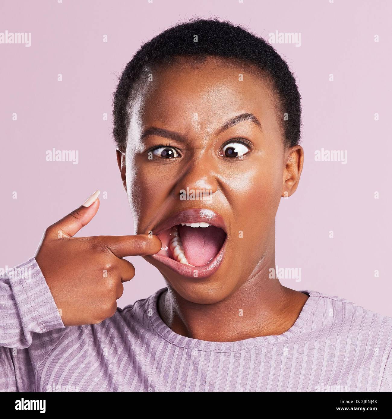 Why not just be weird. Studio shot of a young woman making a silly face ...