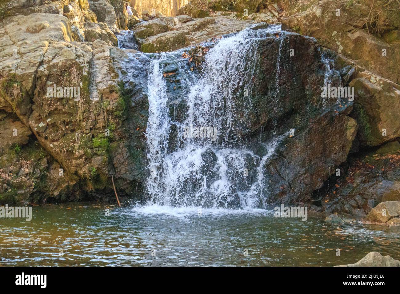 A beautiful shot of a waterfall falling from big rock and making river ...