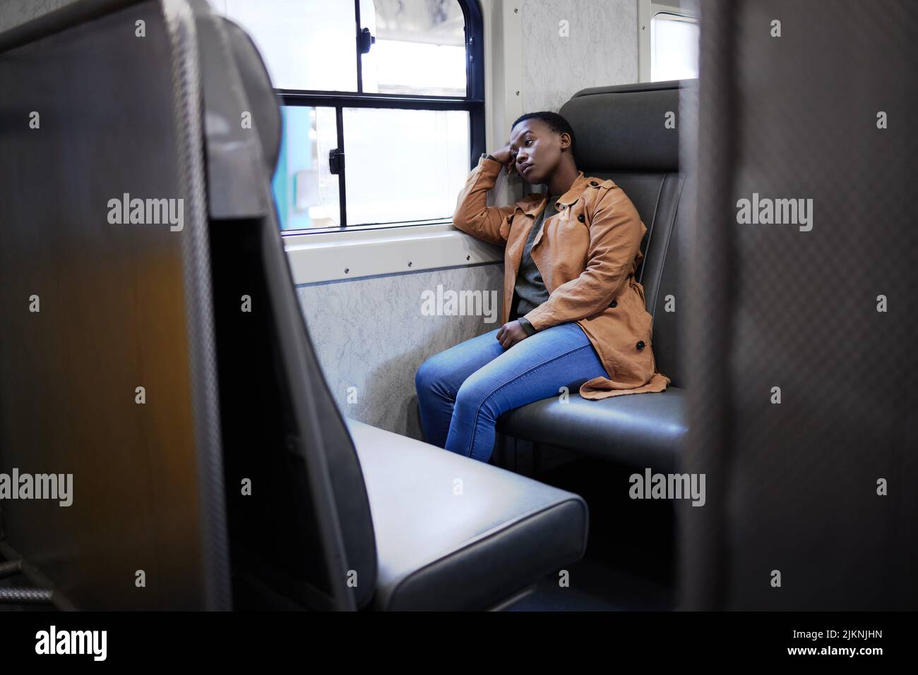 Shes running away. a young woman looking depressed while staring out ...