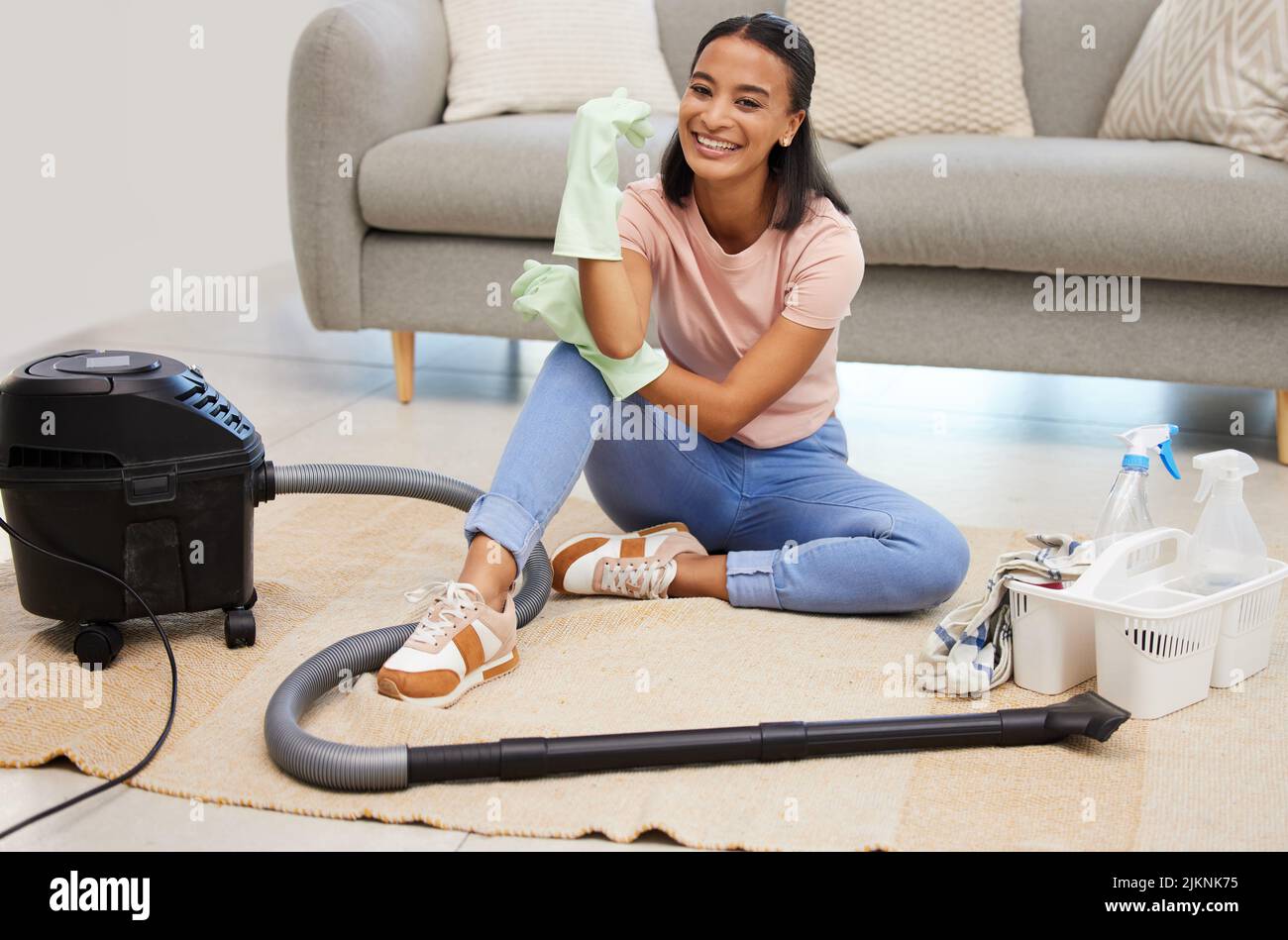 Vacuuming is my favorite chore. a young woman sitting on the floor with ...