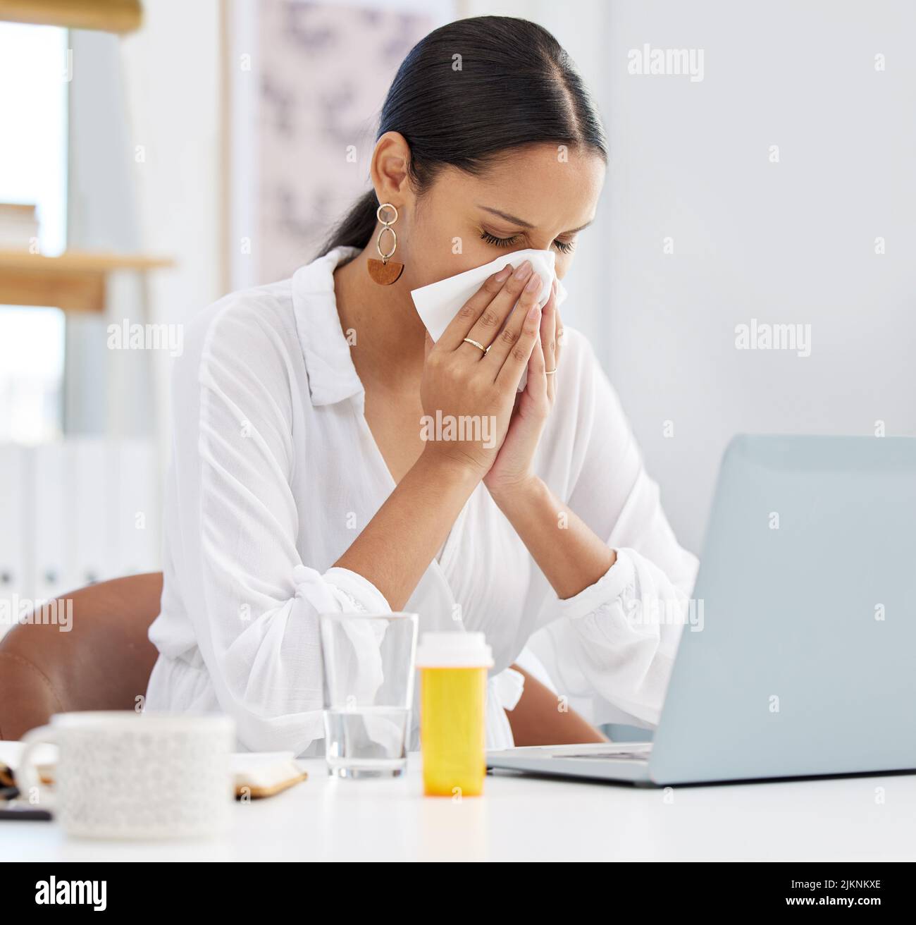 I promise Im not sick. a young businesswoman sitting at her desk ...