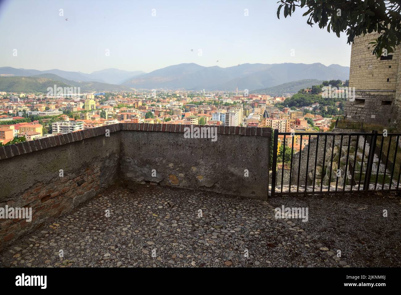 Balcony next to the walls of a castle on a cliff and a city below with ...