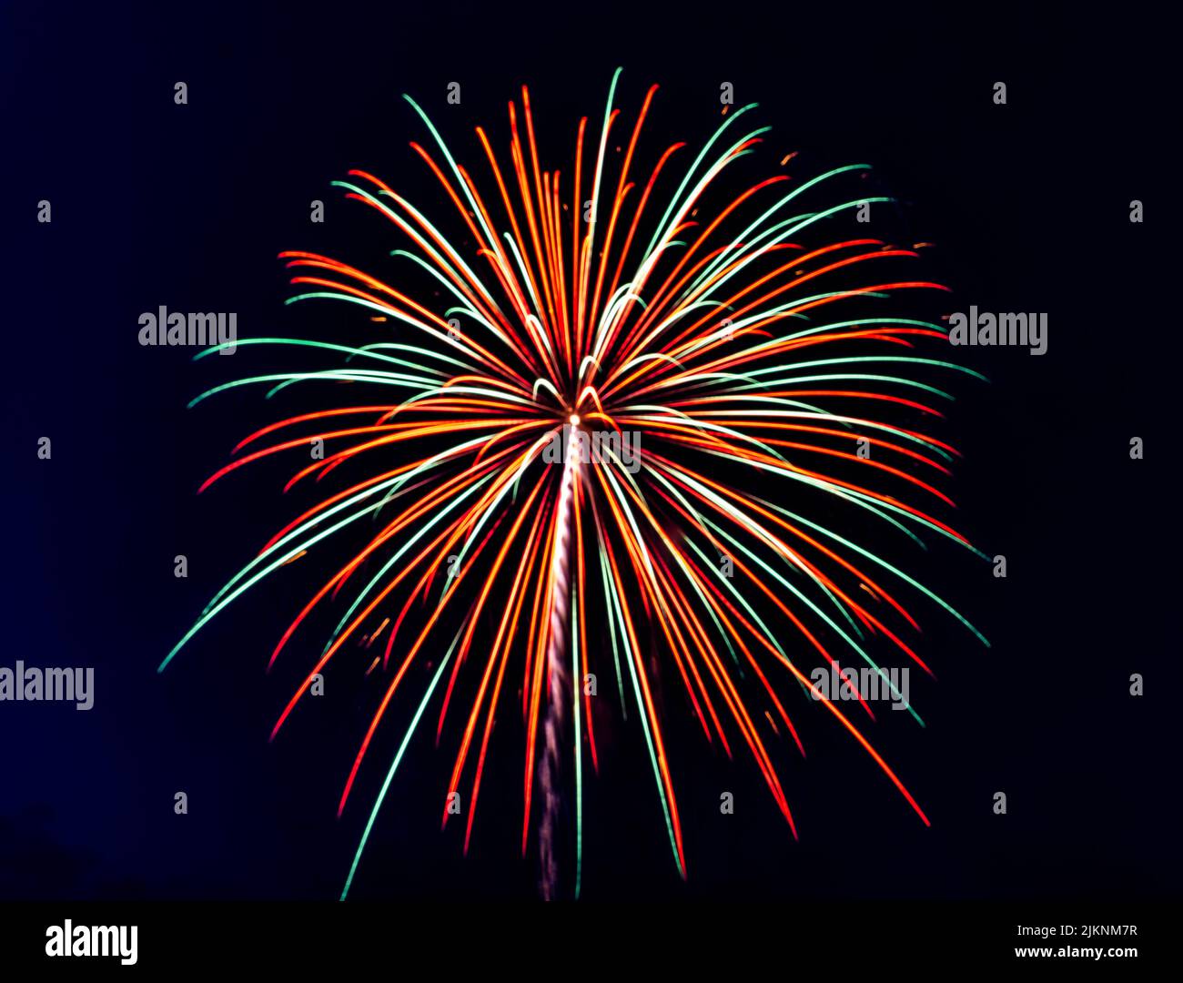 The bright colorful splashes of firework in the dark sky during a ...
