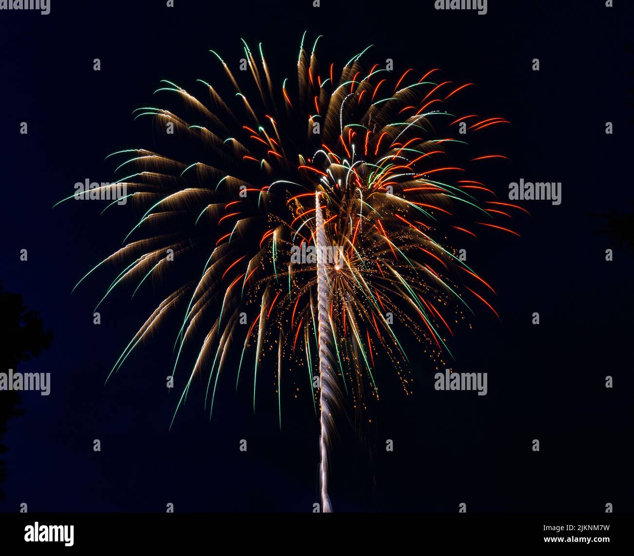 The bright colorful splashes of firework in the dark sky during a ...
