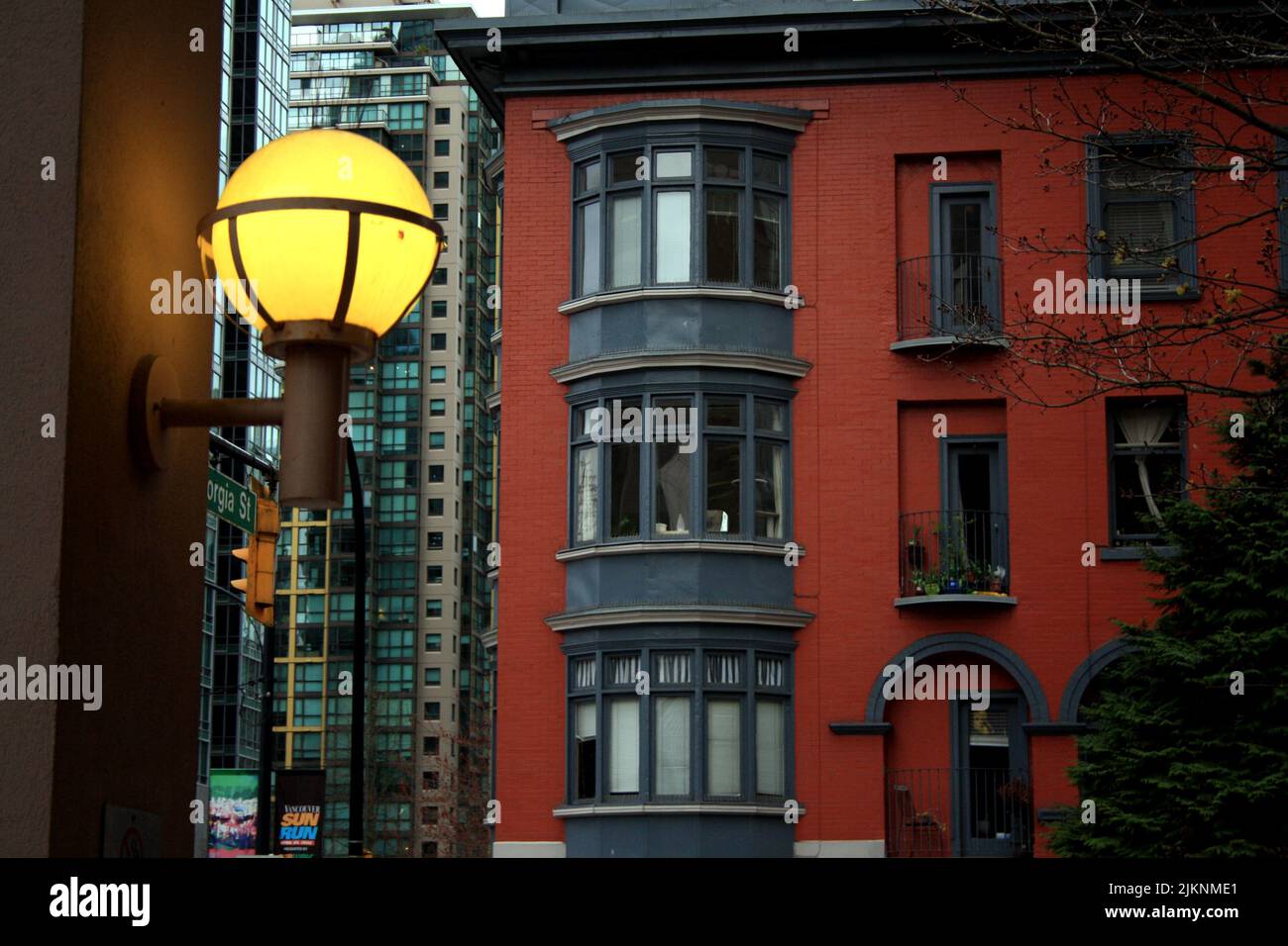 The yellow street lamp against a red building in downtown Vancouver ...