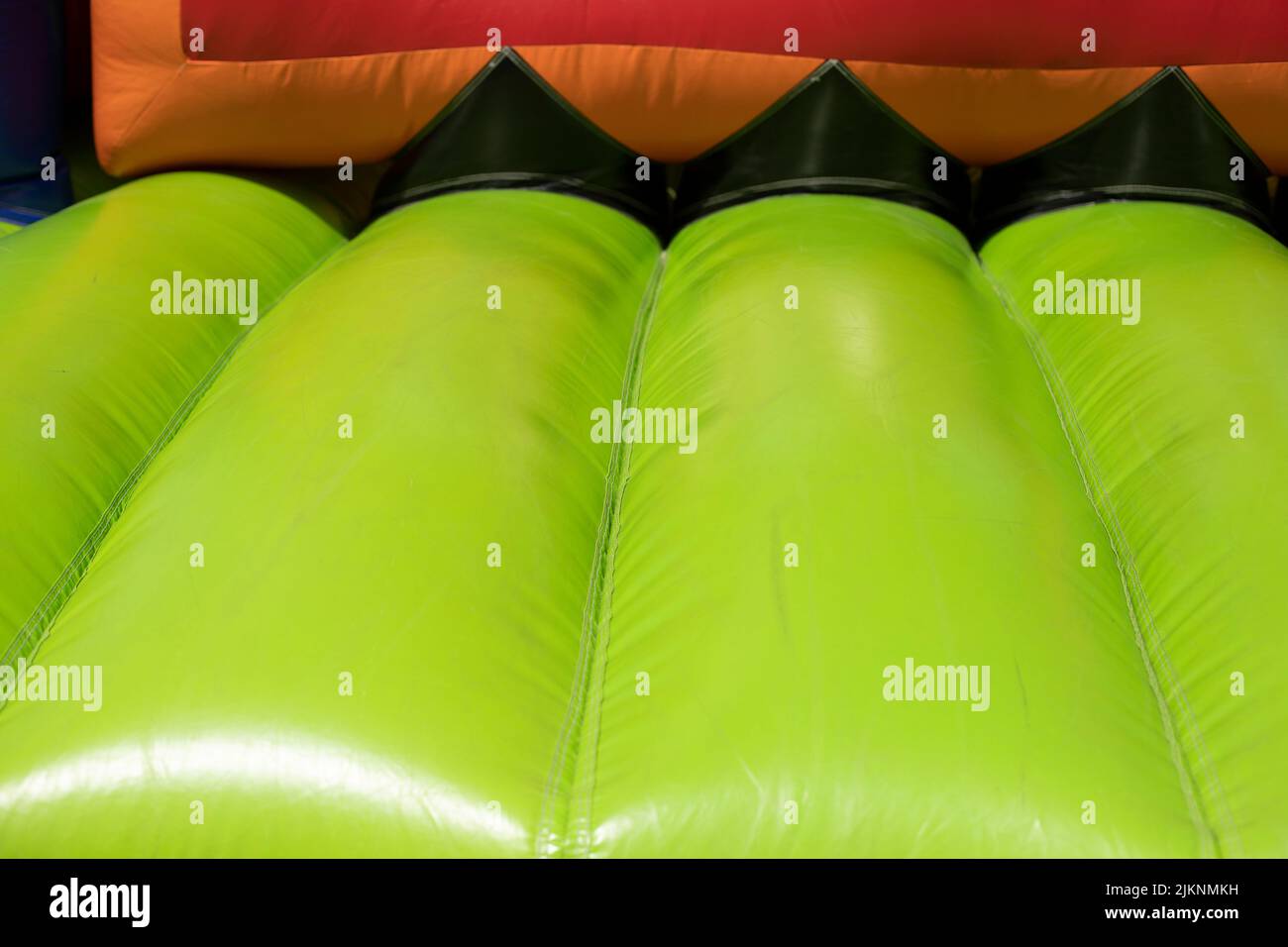 Inflatable trampoline. Amusement park. Green rubber. Obstacle bar in ...