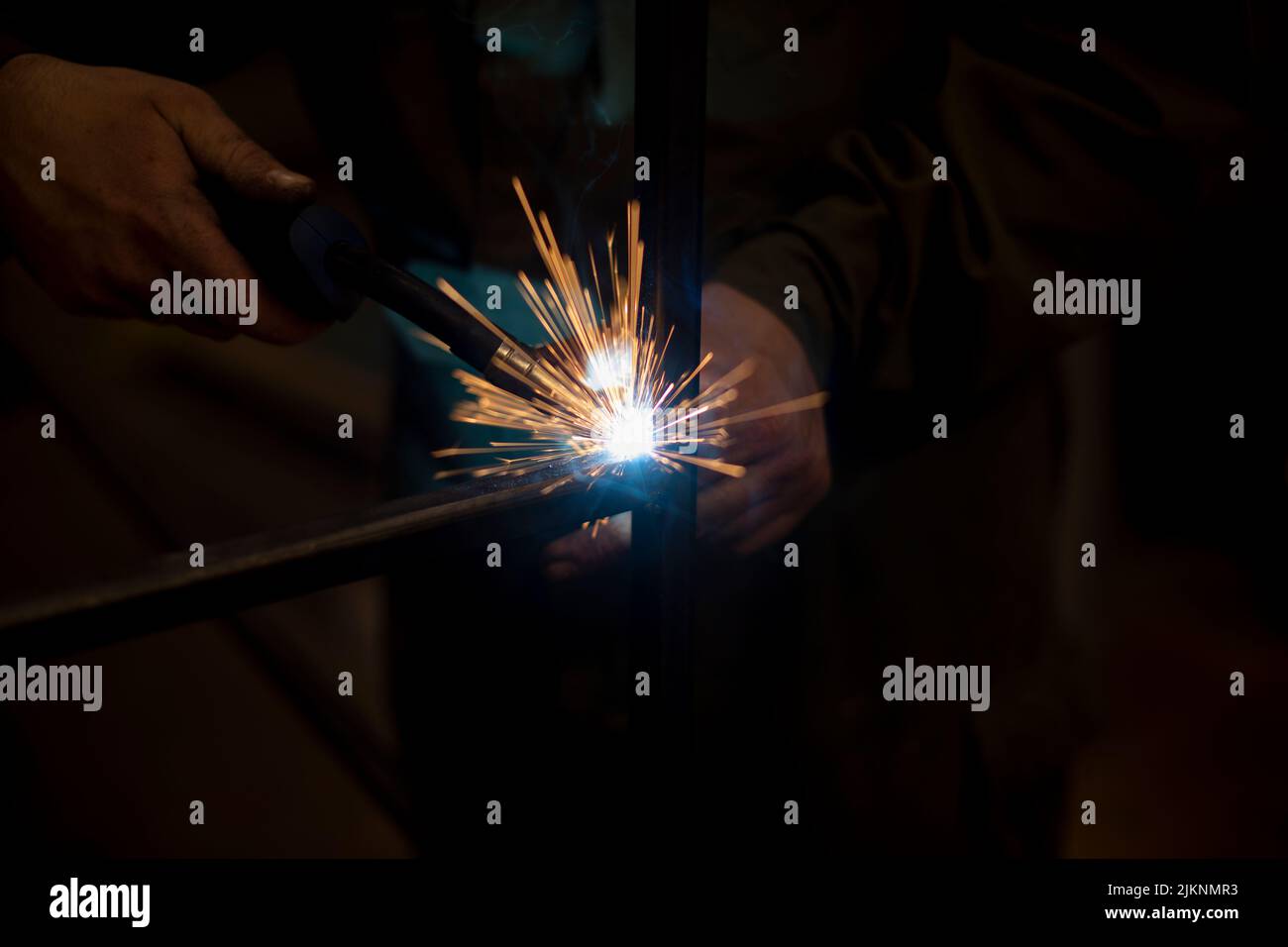 Welding work on metal. Blue fire from high temperature. Creation of ...