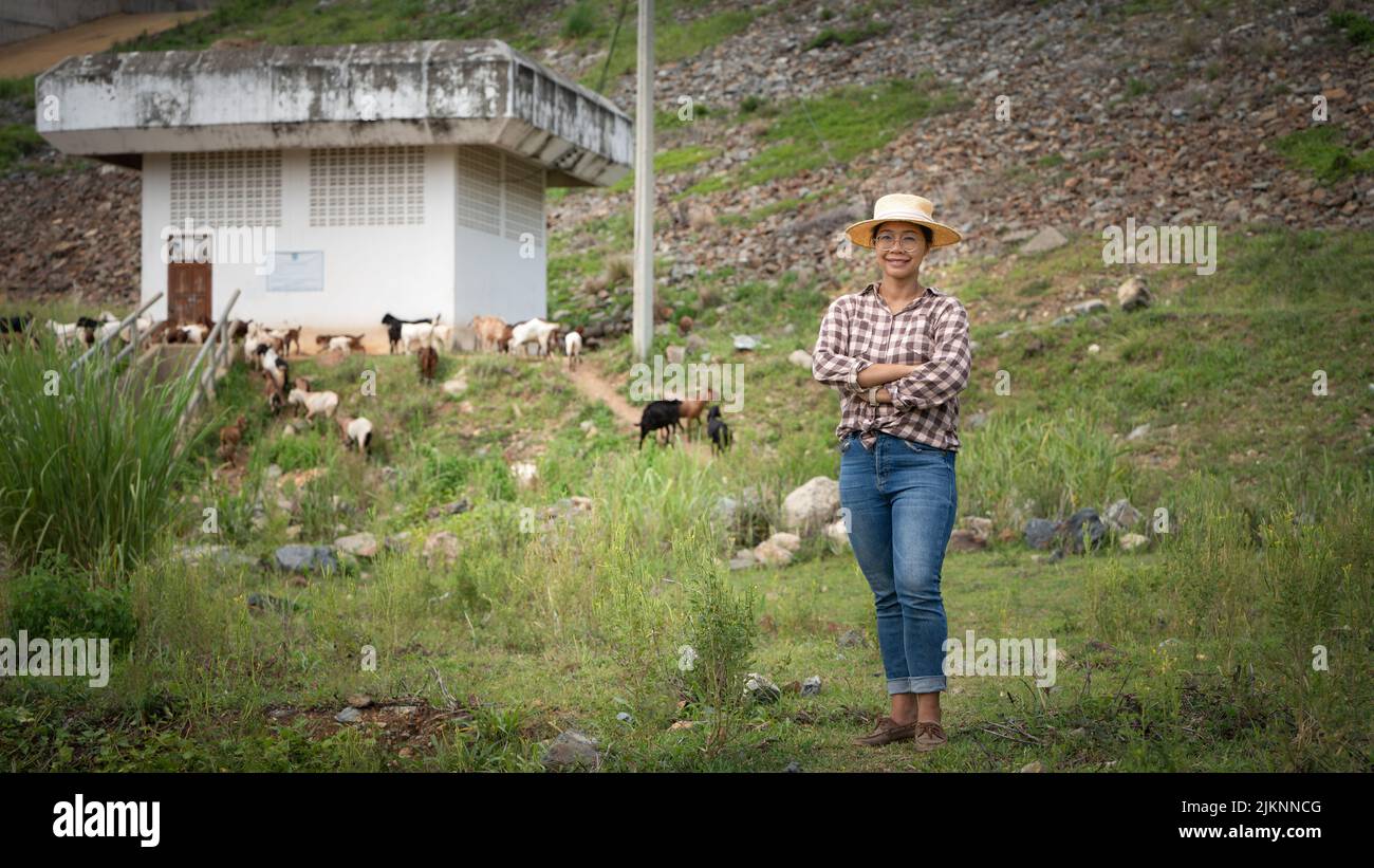 Female Woman worker posing on a Goats dairy farm out door ranch a farm ...