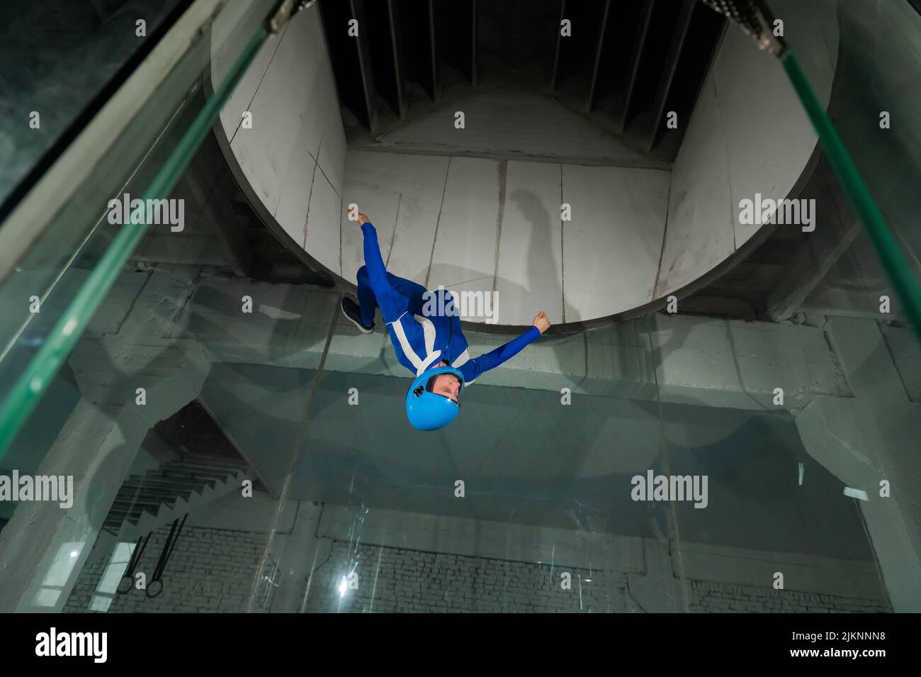 A man in overalls and a protective helmet enjoys flying in a wind ...