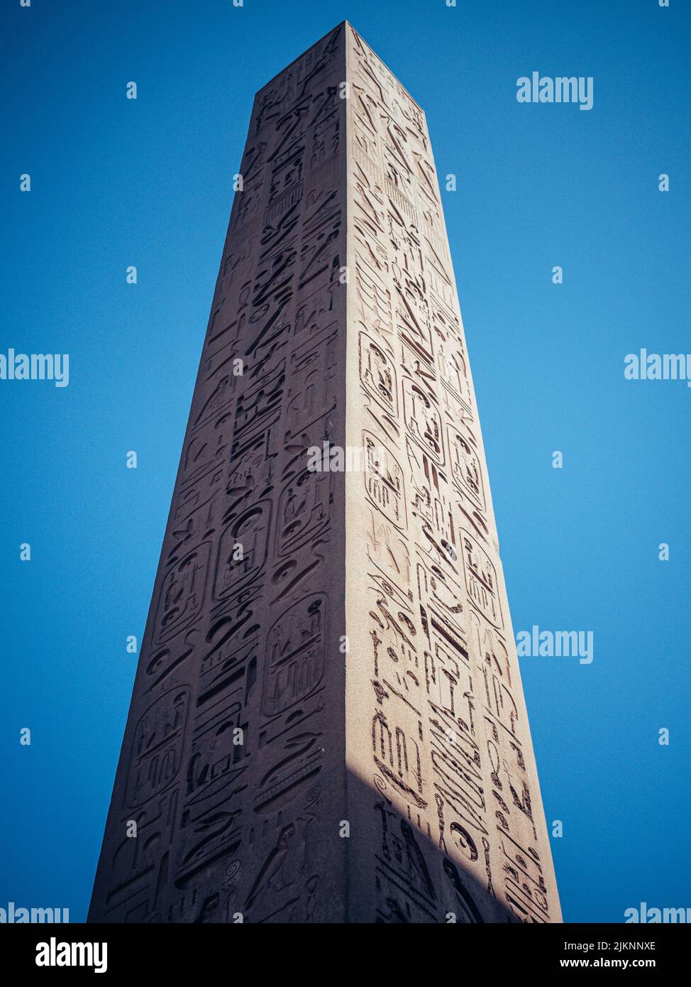 A vertical low angle shot of a tall historic obelisk with carvings in ...