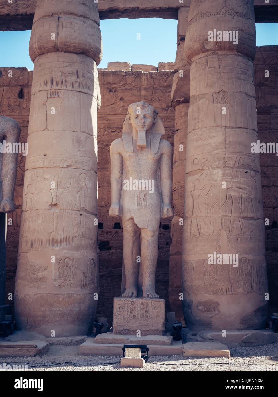 A vertical shot of a pharaoh statue between the columns in the Mortuary ...