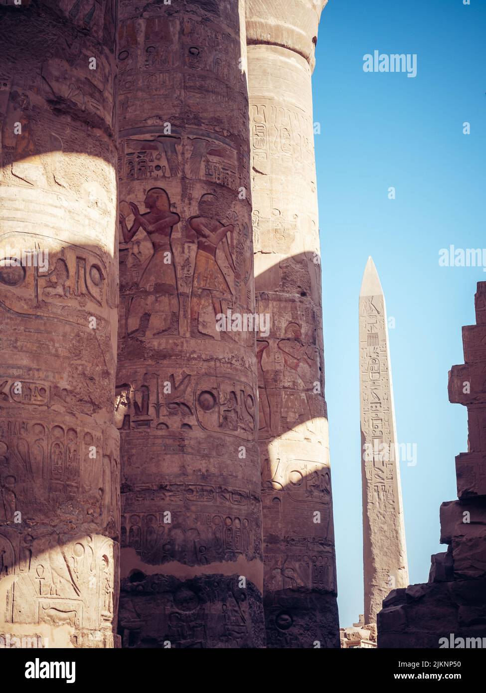 A vertical shot of the ancient columns with Egyptian carvings in Karnak ...