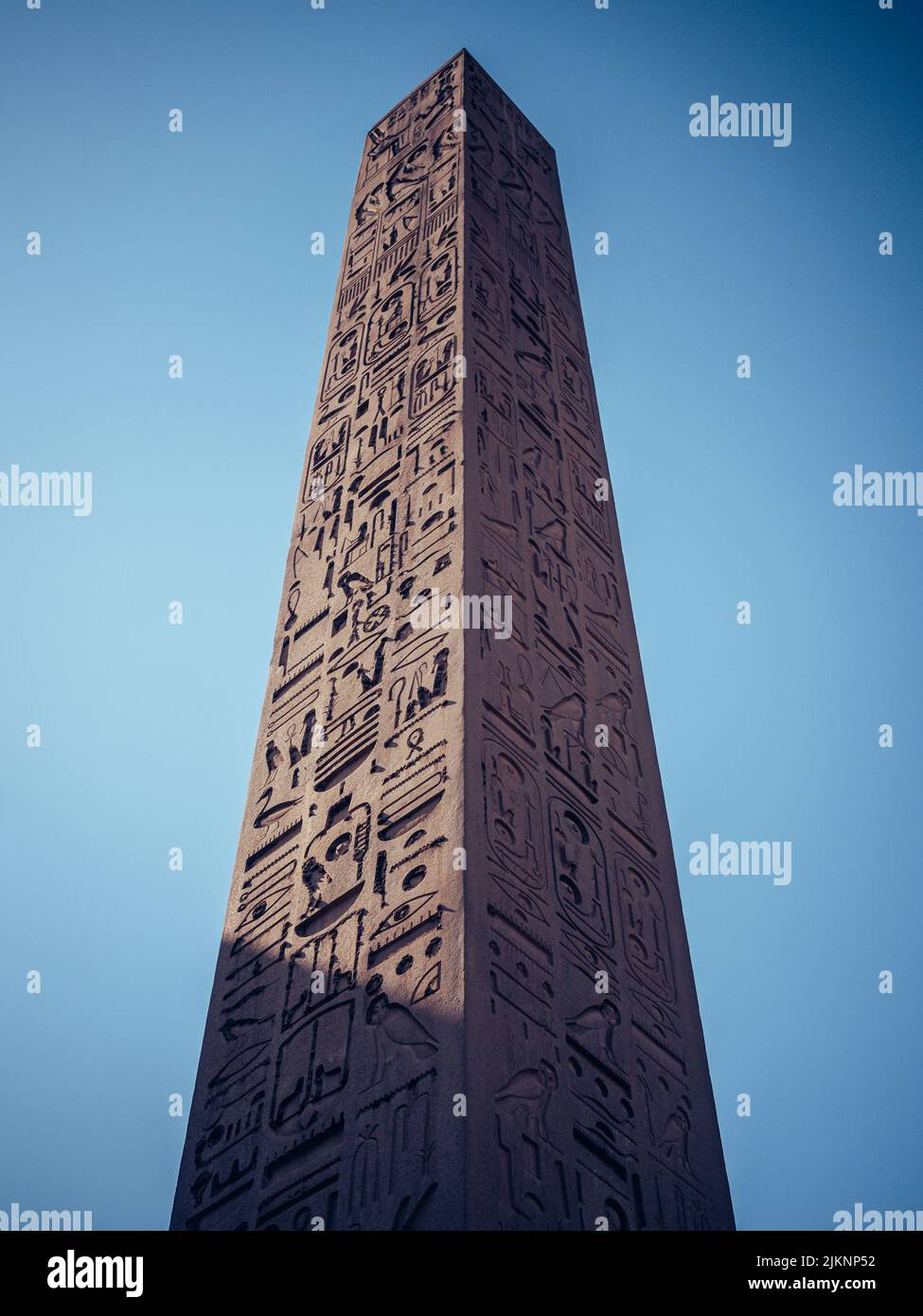 A vertical low angle shot of a tall historic obelisk with carvings in ...