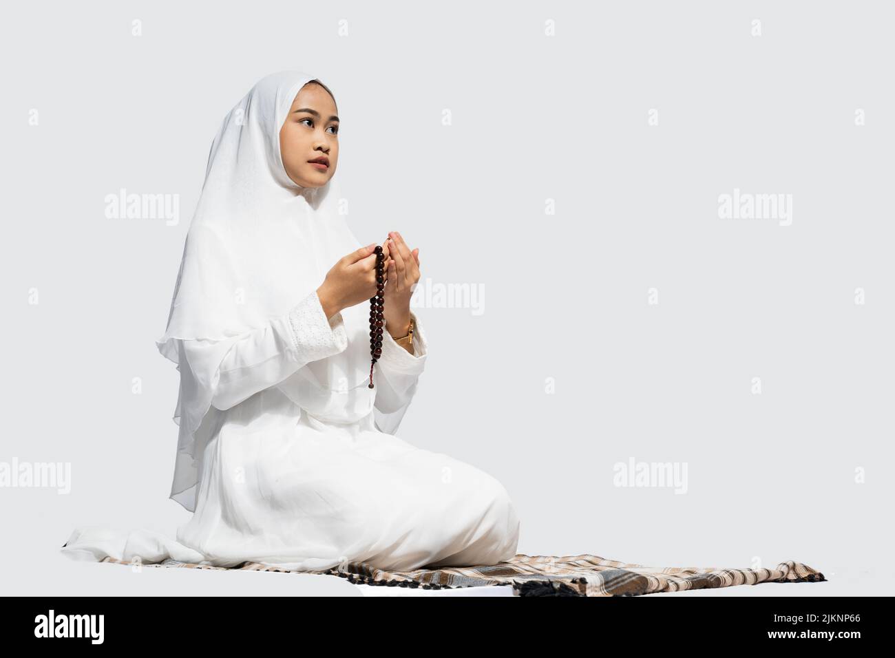 Asian woman wearing ihram clothes praying with prayer beads Stock Photo ...