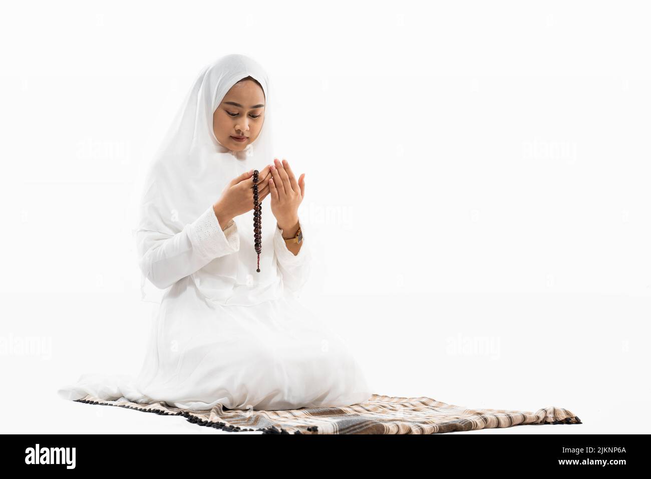 Asian woman wearing ihram clothes praying with prayer rug Stock Photo ...