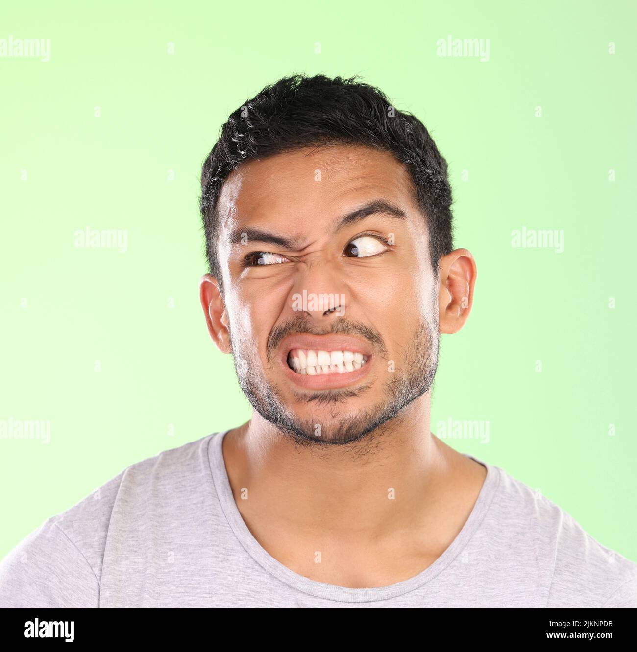 Showing a little grit. a handsome young man making a face against a ...