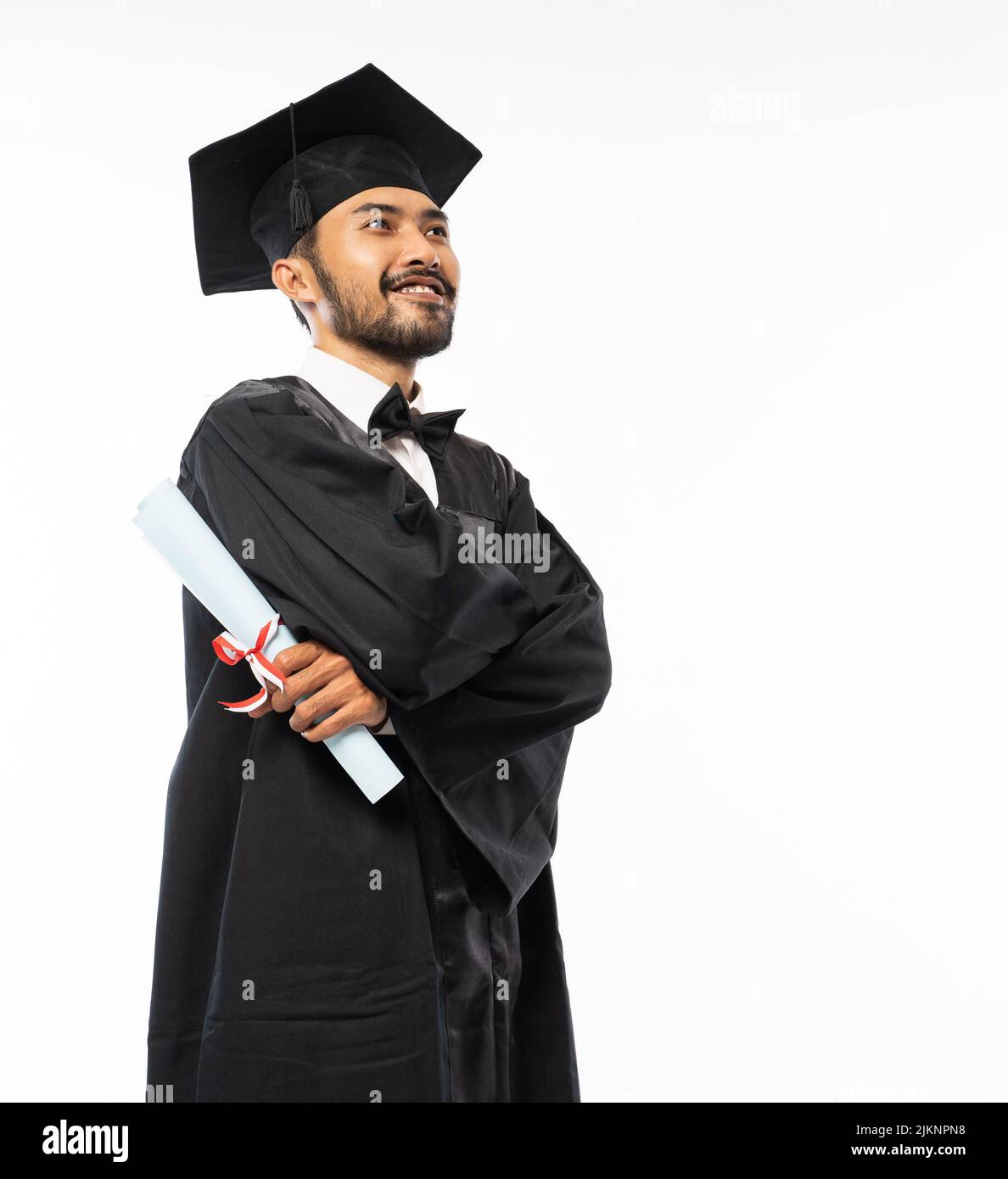 Graduating man wearing a toga with folded hands standing Stock Photo ...