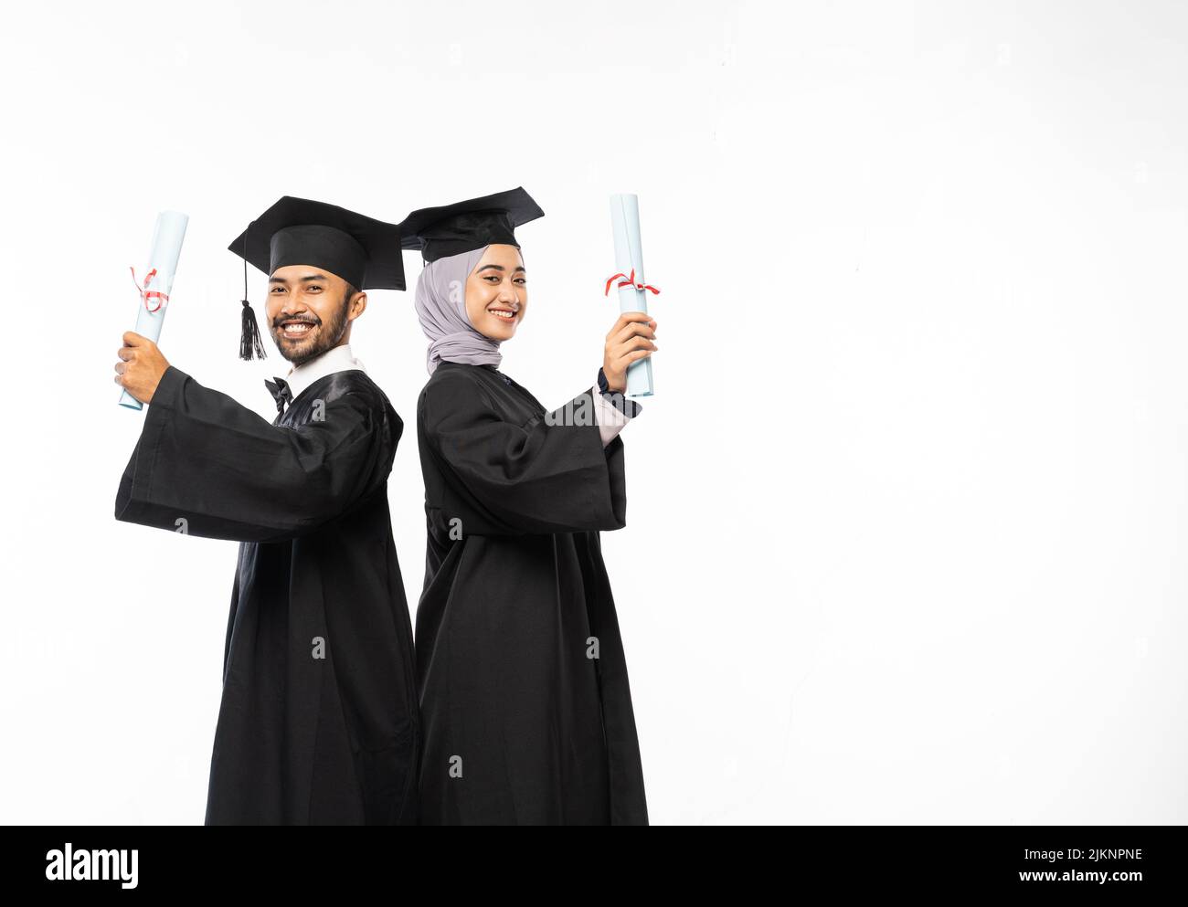 Happy graduate couple in black toga holding rolls of certificate Stock ...