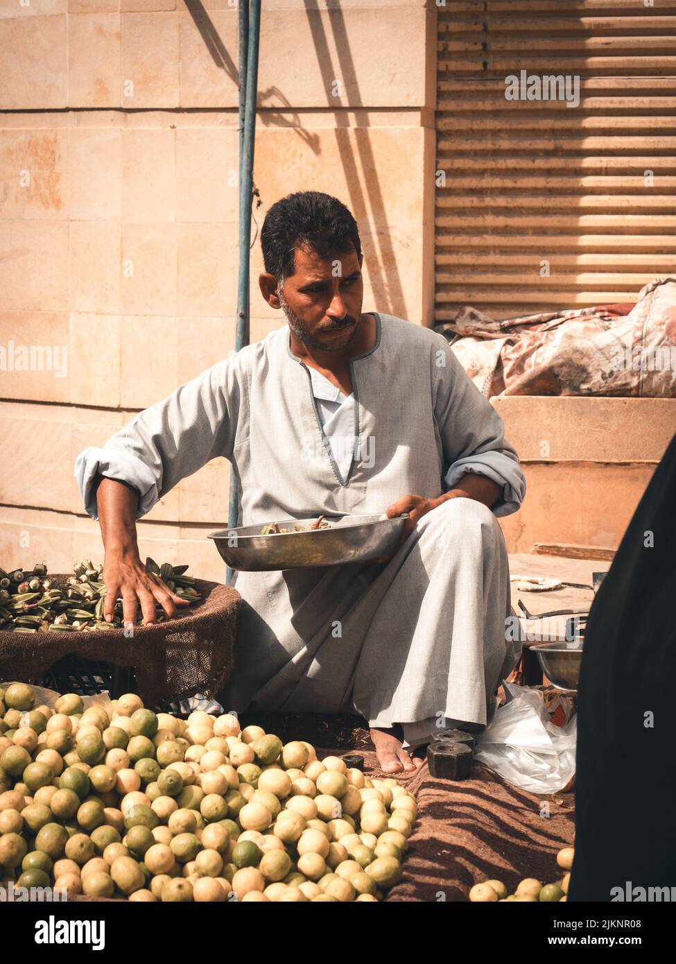 A beautiful shot of a street vendor wearing galabeya sitting on the ...