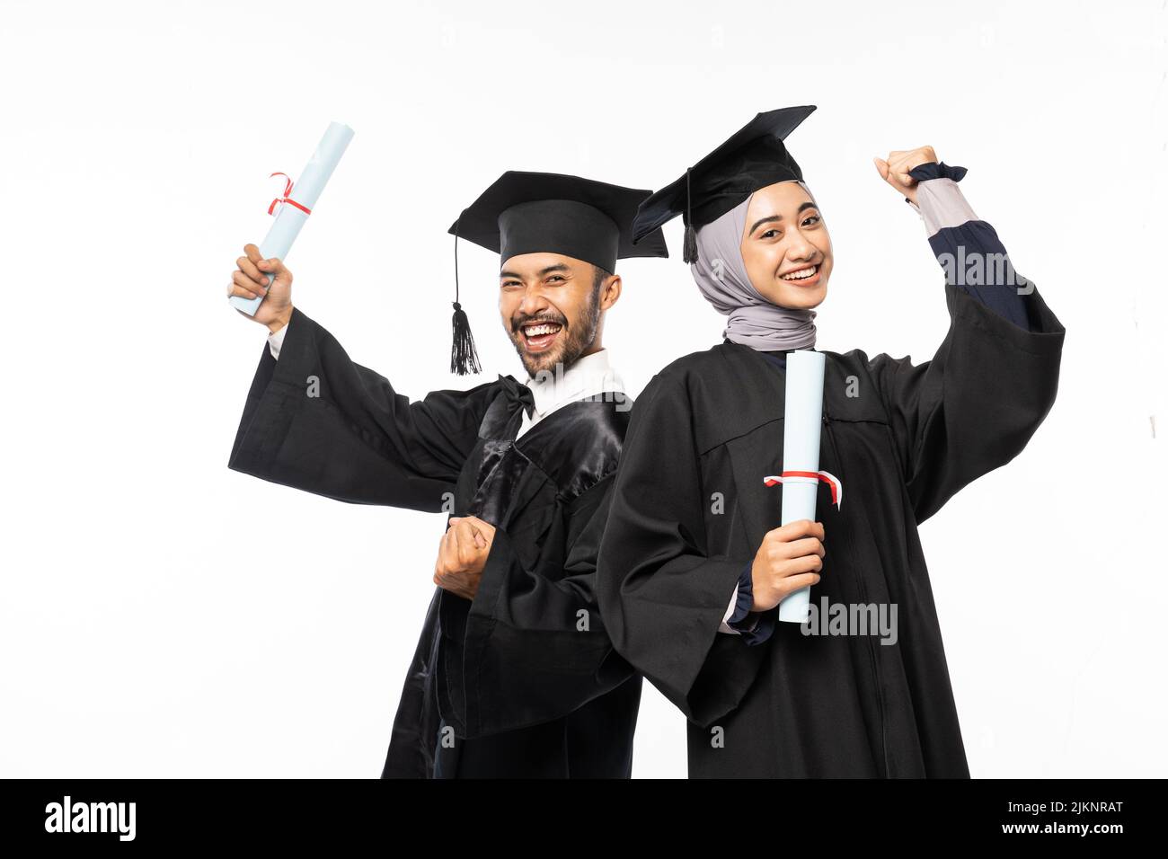 Two excited asian graduate students carrying certificate on white ...