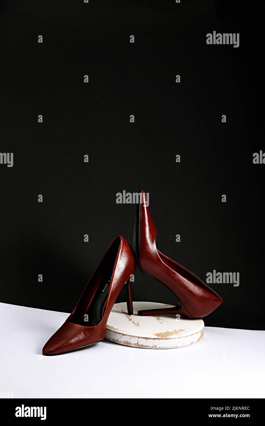 A vertical shot of red heels in black background Stock Photo - Alamy
