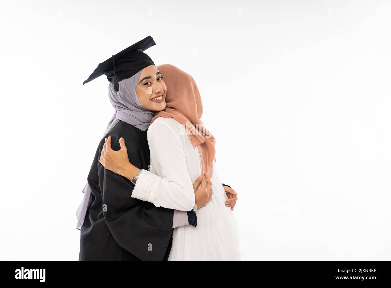 Happy graduate female student wearing toga meeting her friend Stock ...