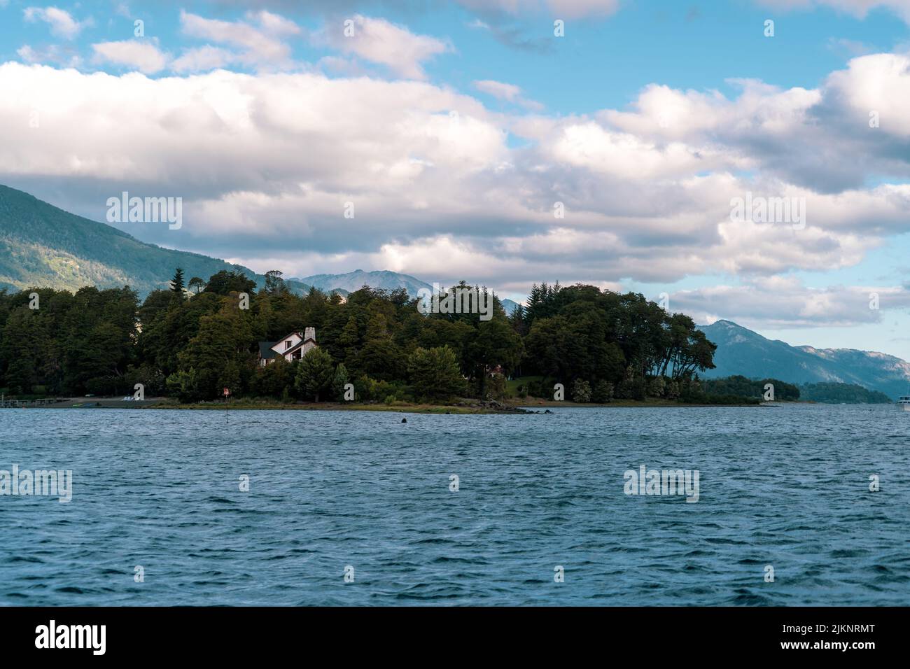 A beautiful scene of blue water sea with far trees and blue sky on the ...