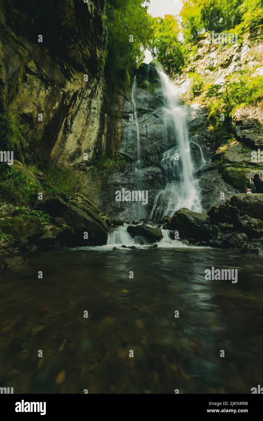 A natural view of a waterfall flowing downstream on a sunny day Stock ...