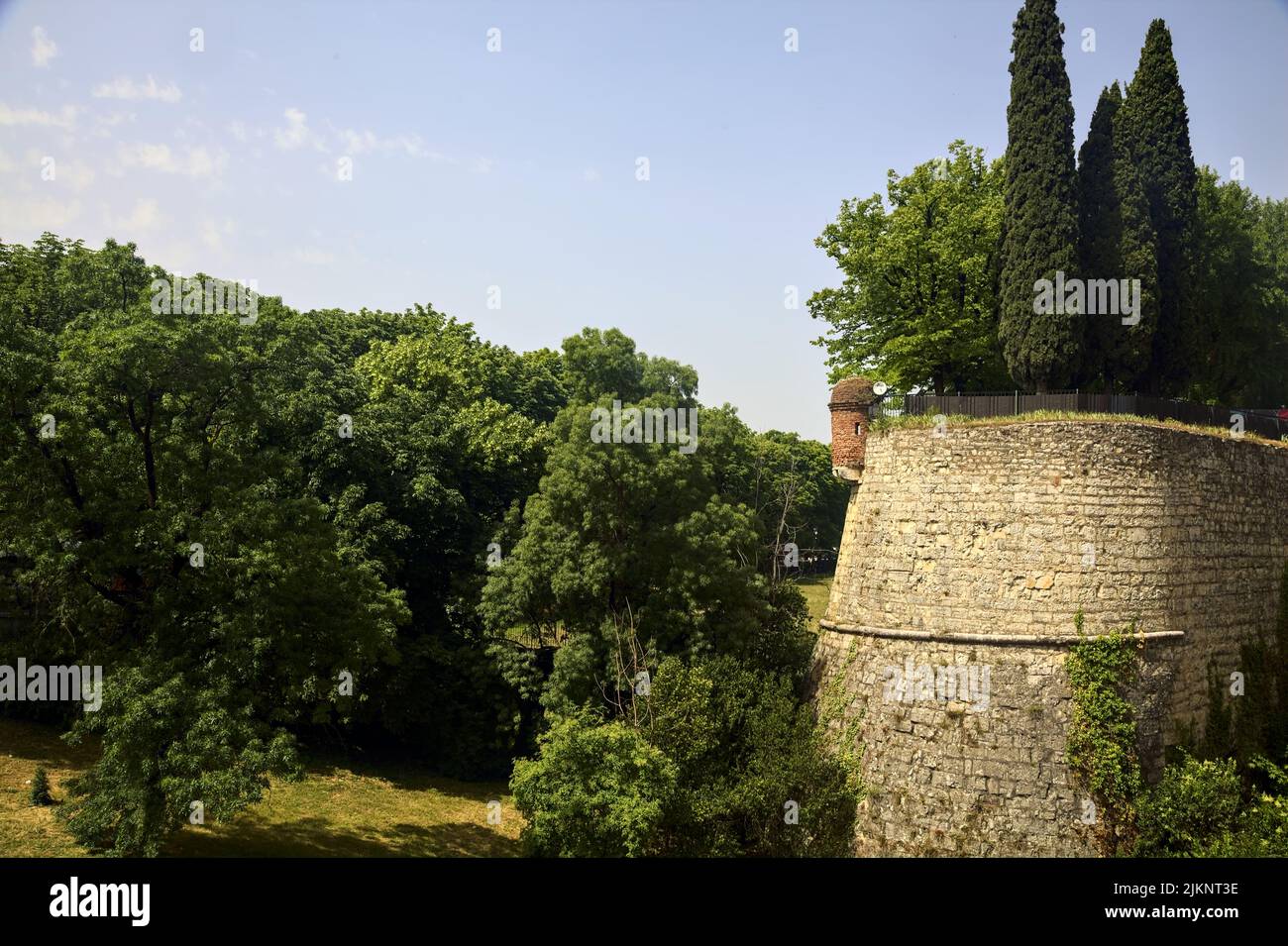 Fortification wall and moat with trees of a castle in a park on a sunny ...