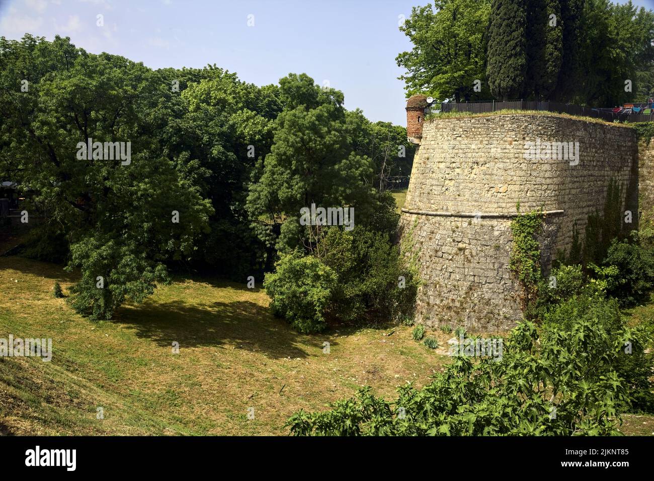 Fortification wall and moat with trees of a castle in a park on a sunny ...